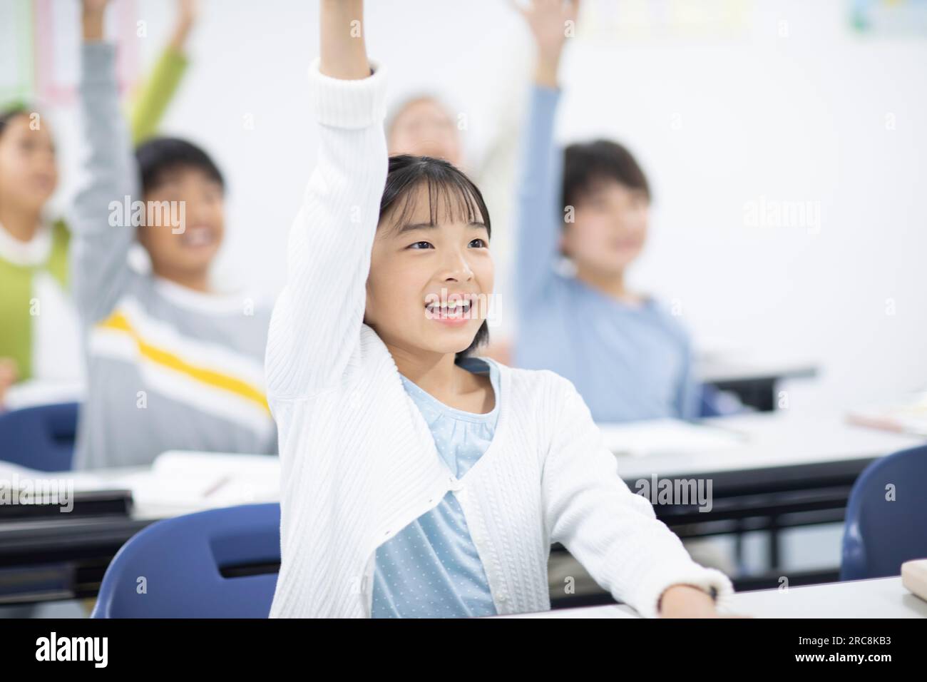 A girl cheerfully raising her hand Stock Photo - Alamy