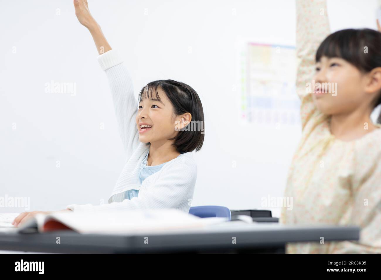 Girl raising her hand cheerfully Stock Photo - Alamy