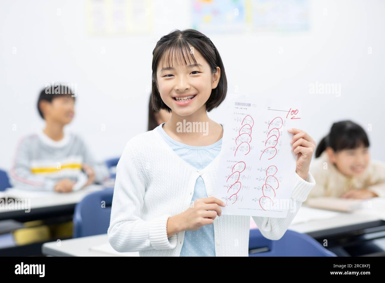 Elementary school student holding a test and smiling Stock Photo - Alamy