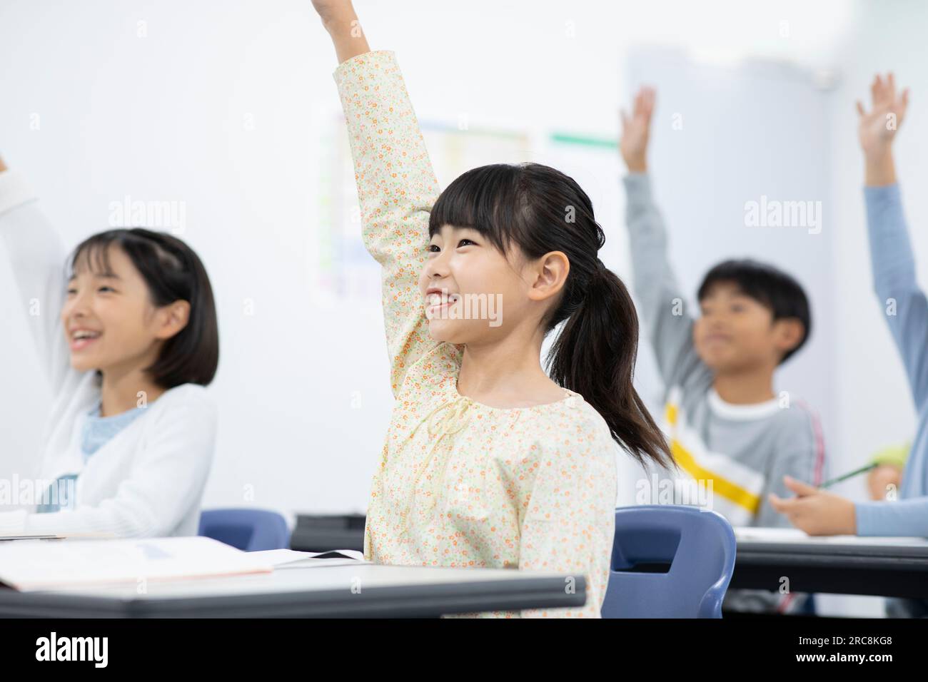 Girl raising her hand cheerfully Stock Photo - Alamy
