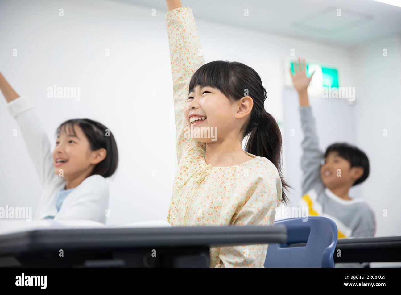 Girl raising her hand cheerfully Stock Photo - Alamy