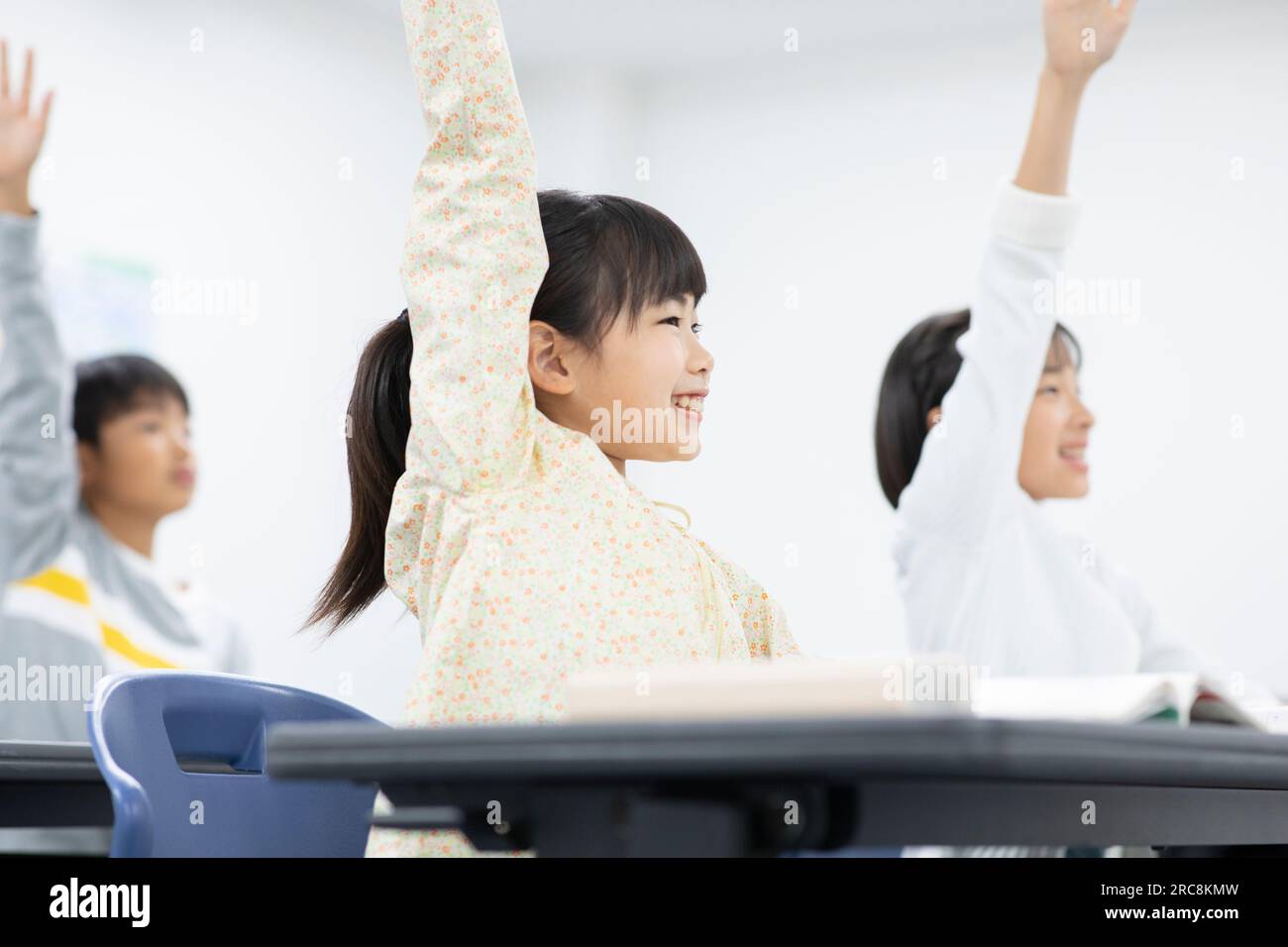 Girl raising her hand cheerfully Stock Photo - Alamy