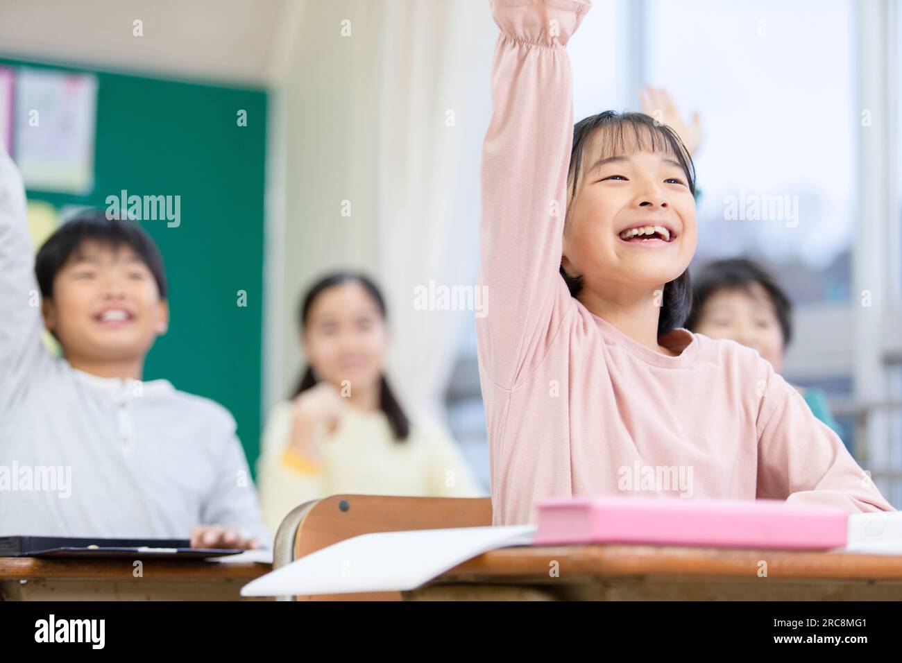 A girl cheerfully raising her hand Stock Photo - Alamy
