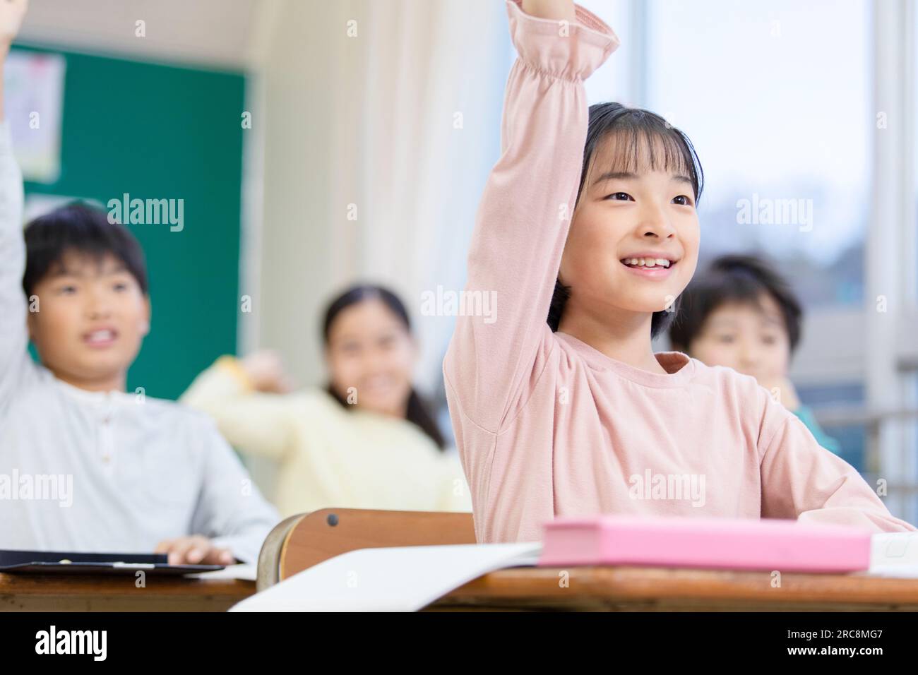 A girl cheerfully raising her hand Stock Photo - Alamy