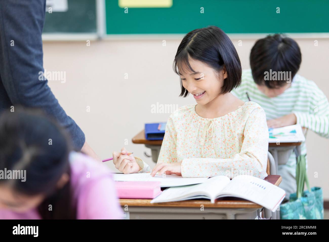 A girl being taught by her teacher in class Stock Photo - Alamy