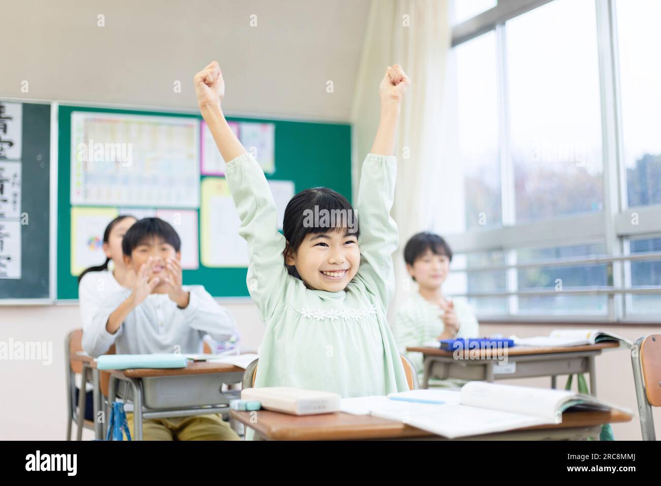 Girl raising her hand cheerfully Stock Photo - Alamy