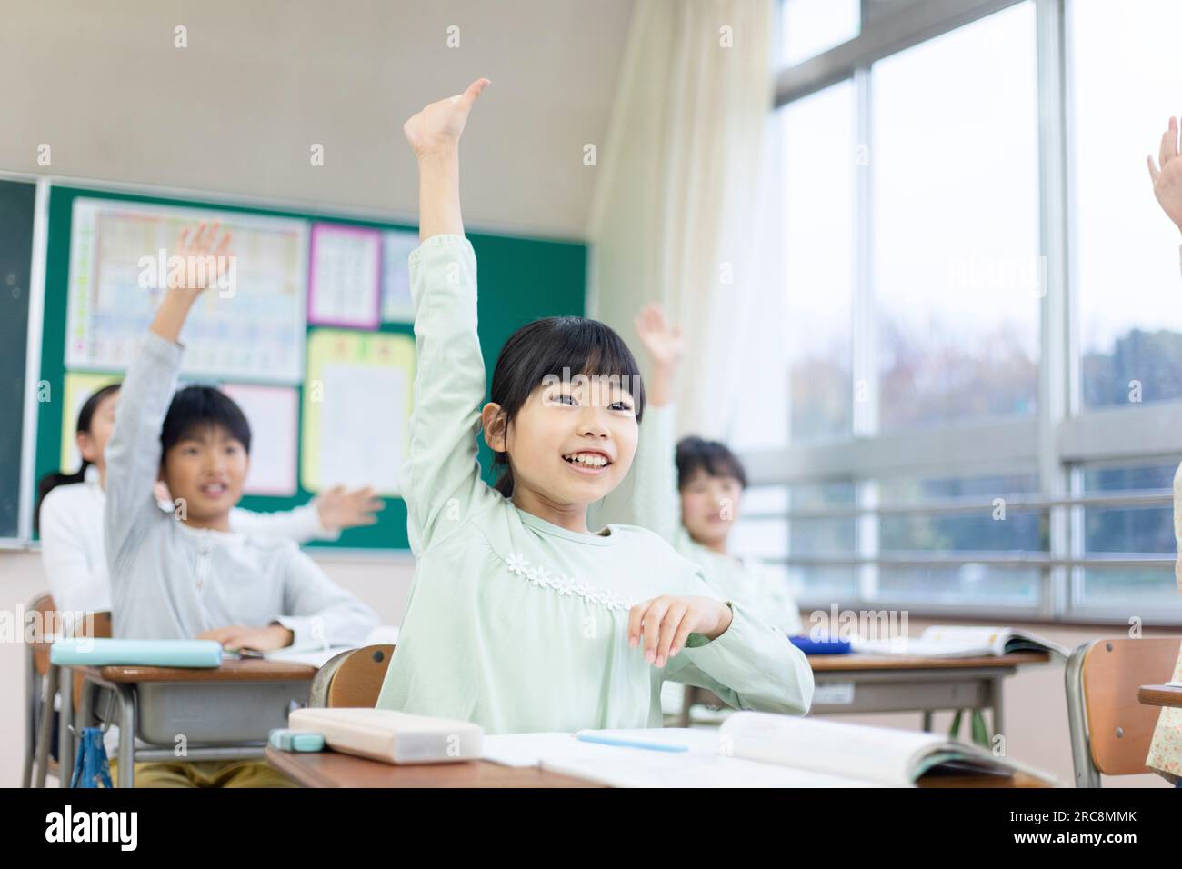 A girl cheerfully raises her hand Stock Photo - Alamy
