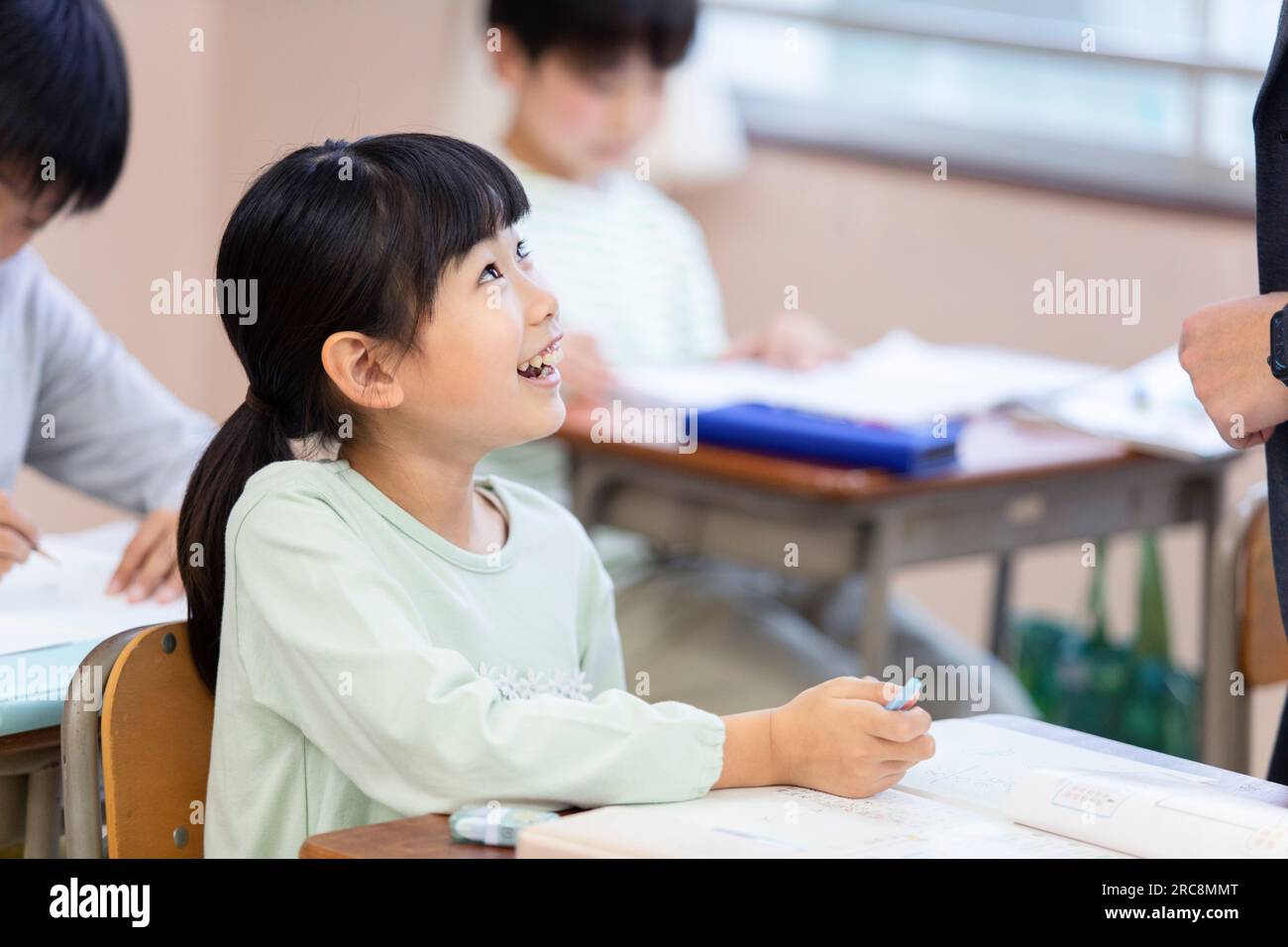 A girl asking her teacher to teach during class Stock Photo - Alamy