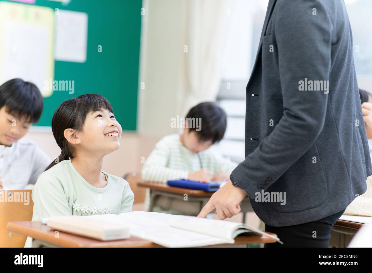 Girl being taught by teacher during class Stock Photo - Alamy