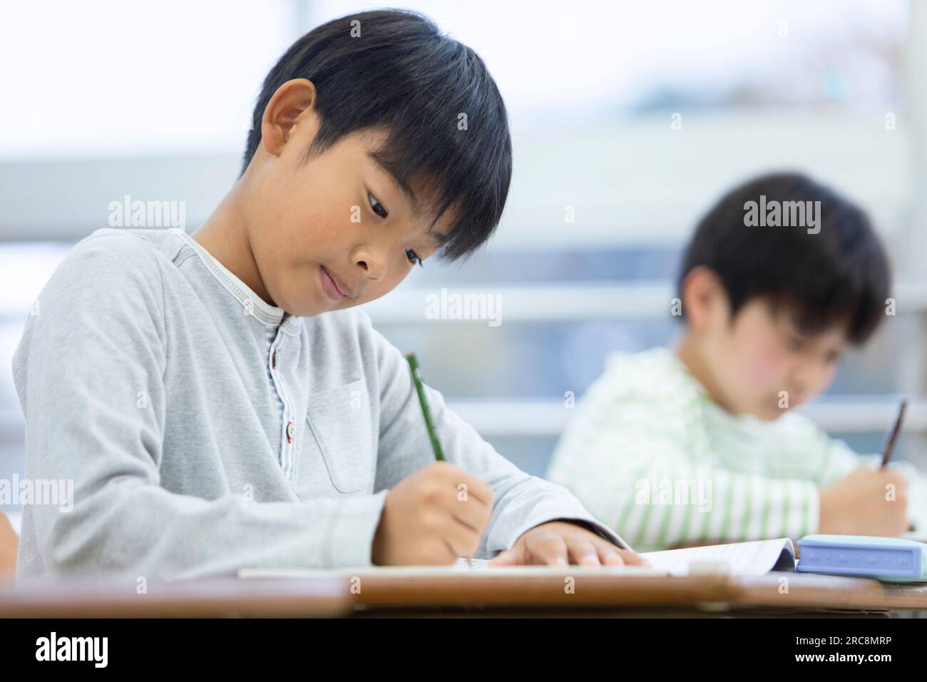An elementary school student studying during class Stock Photo - Alamy