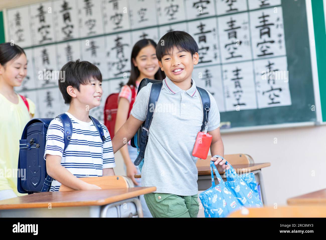 Elementary school students taking their seats after going to school ...