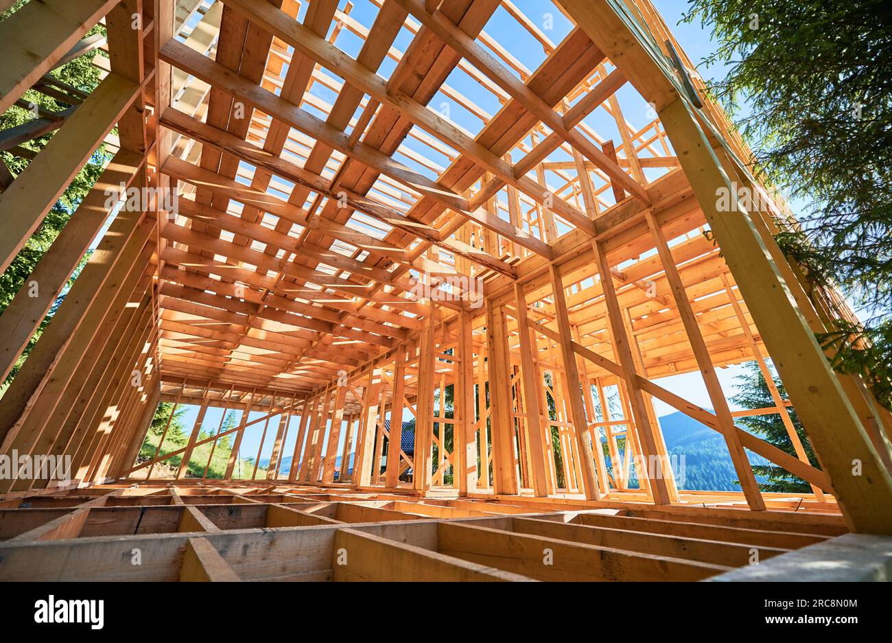 Under-construction residential wooden frame home located near a forest ...