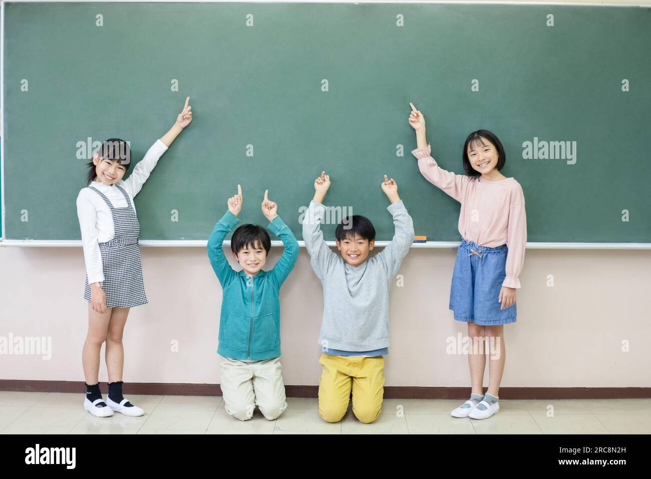 Elementary school students pointing at the blackboard Stock Photo - Alamy