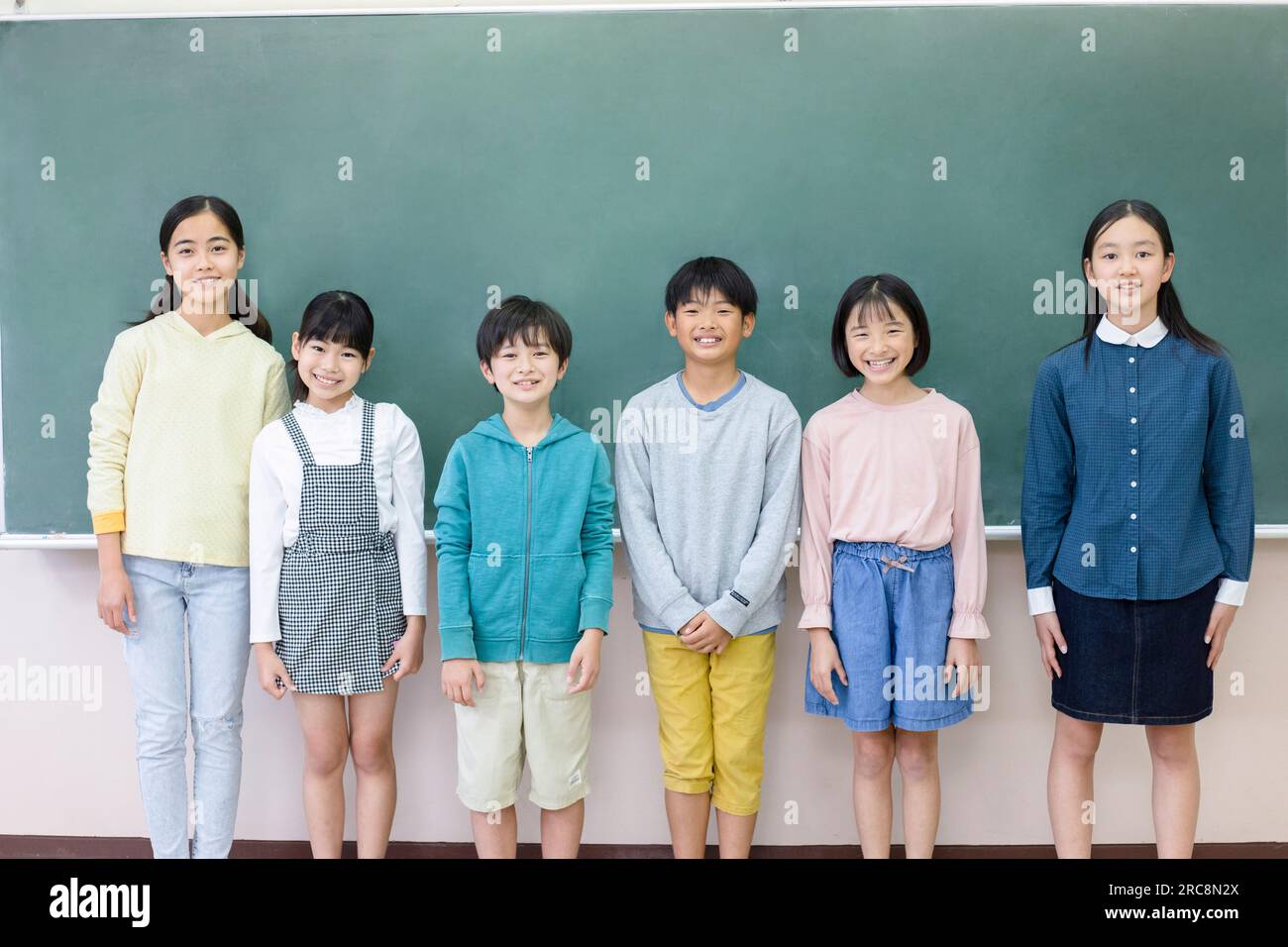 Elementary school students standing in front of the blackboard Stock ...