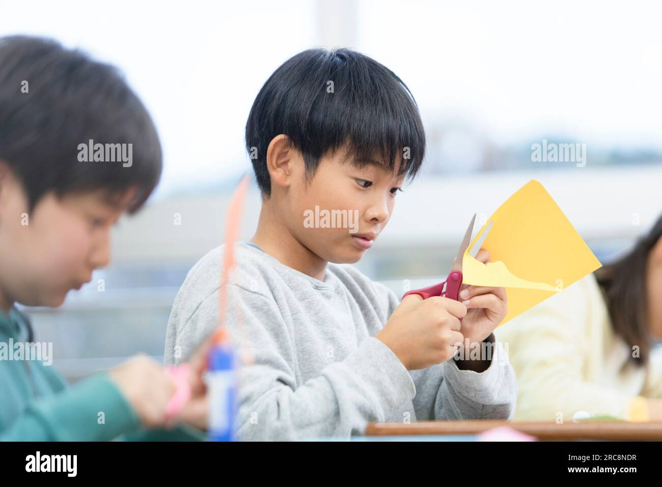 Elementary school students making crafts in the classroom Stock Photo ...