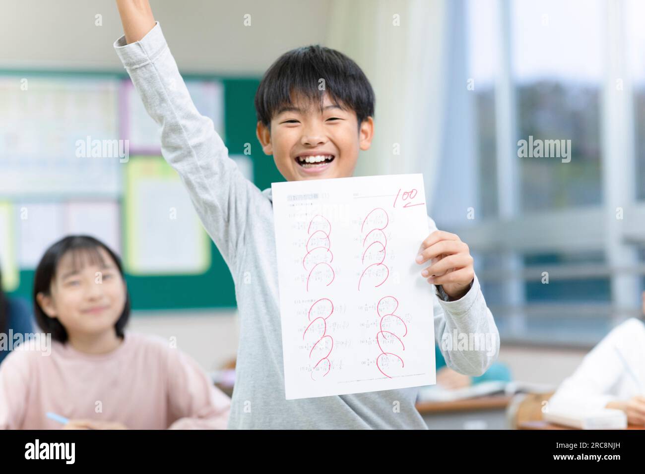 Elementary school student holding and smiling at a test Stock Photo - Alamy