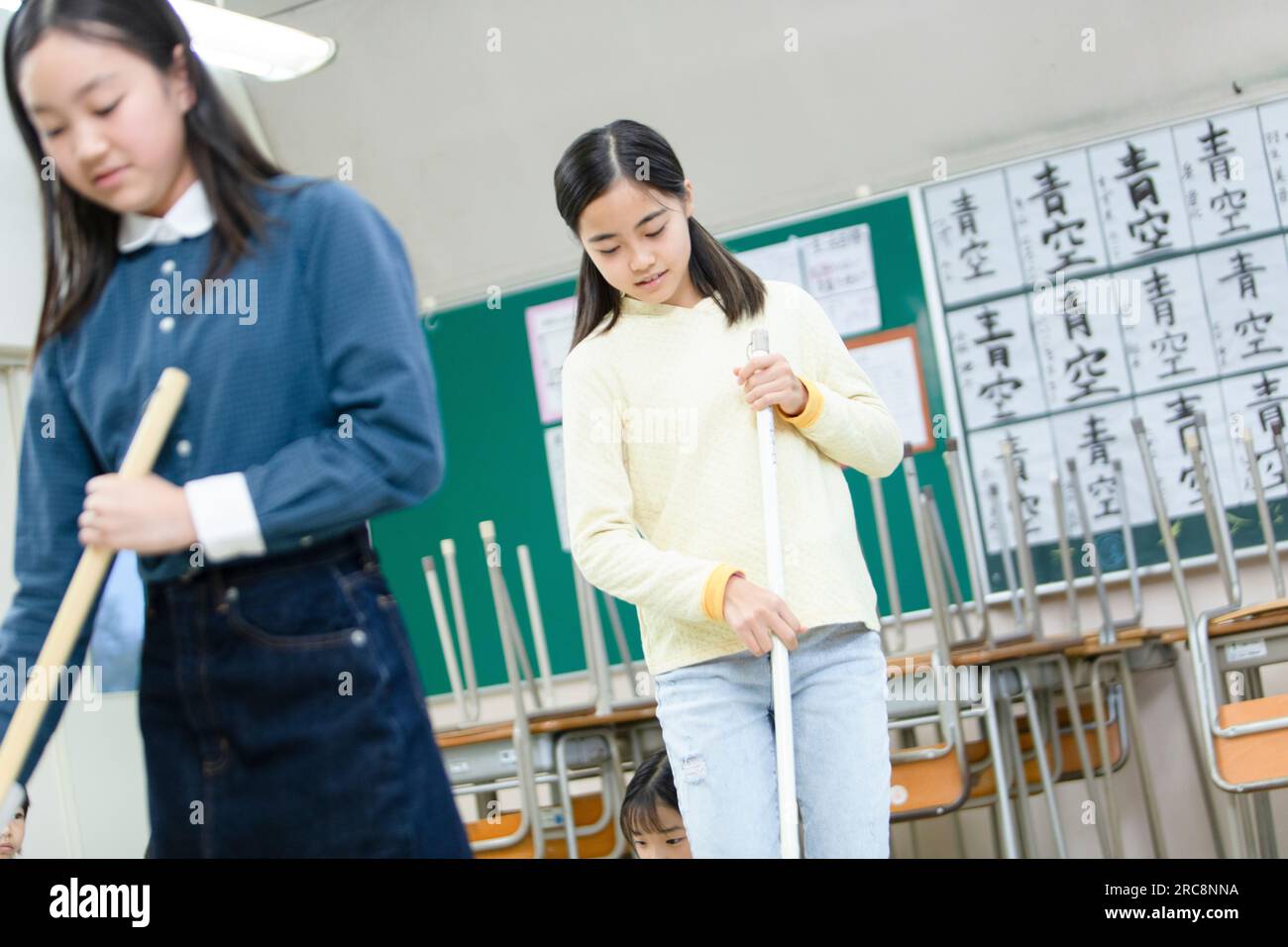 Elementary school students sweeping the classroom Stock Photo - Alamy