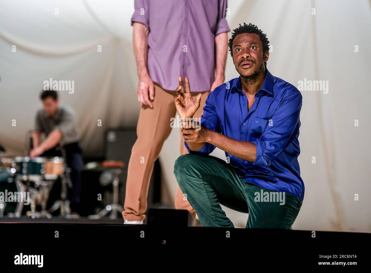 Actor Adama Diop kneels on stage to deliver his lines. Tiago Rodrigues ...