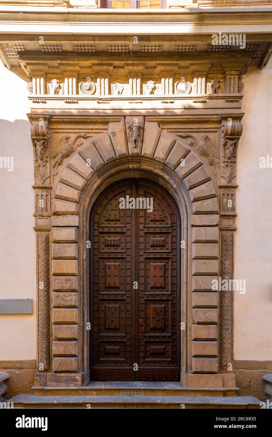 Wooden ornate door with stone arch frame in Florence, Italy. Classical ...