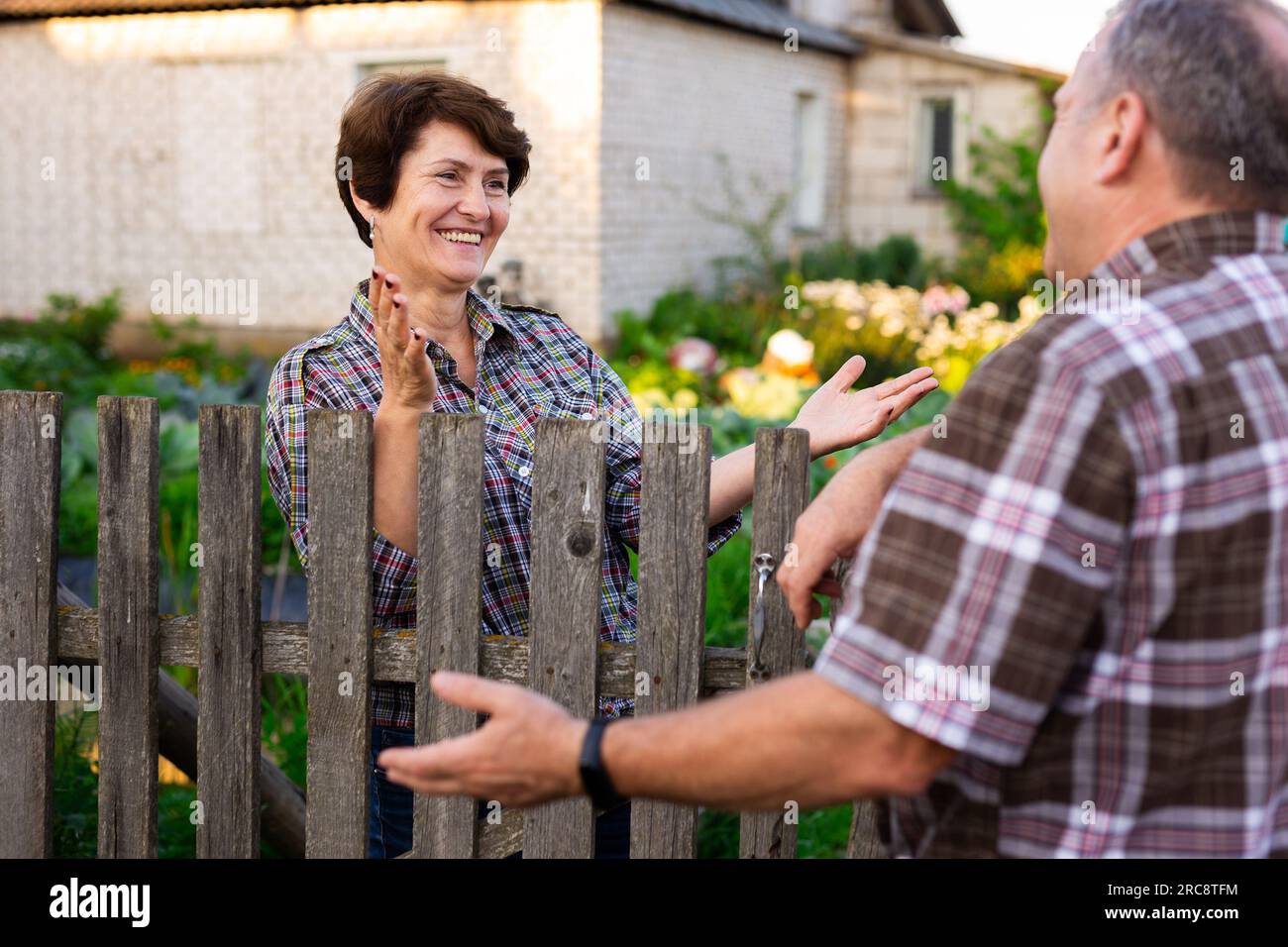 Neighbors talking fence hi-res stock photography and images - Alamy