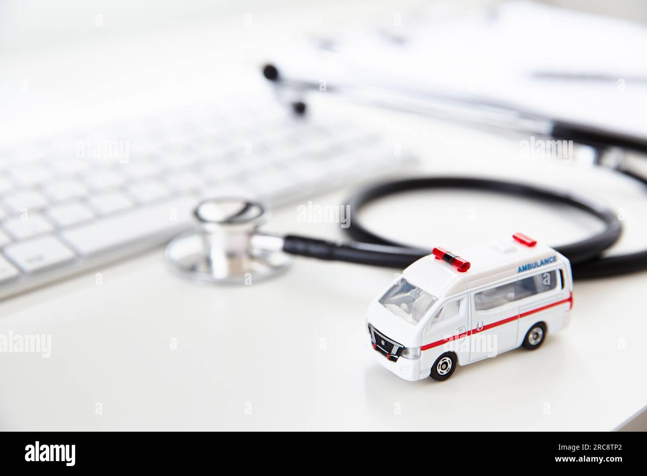A stethoscope in front of a computer and a miniature ambulance Stock ...