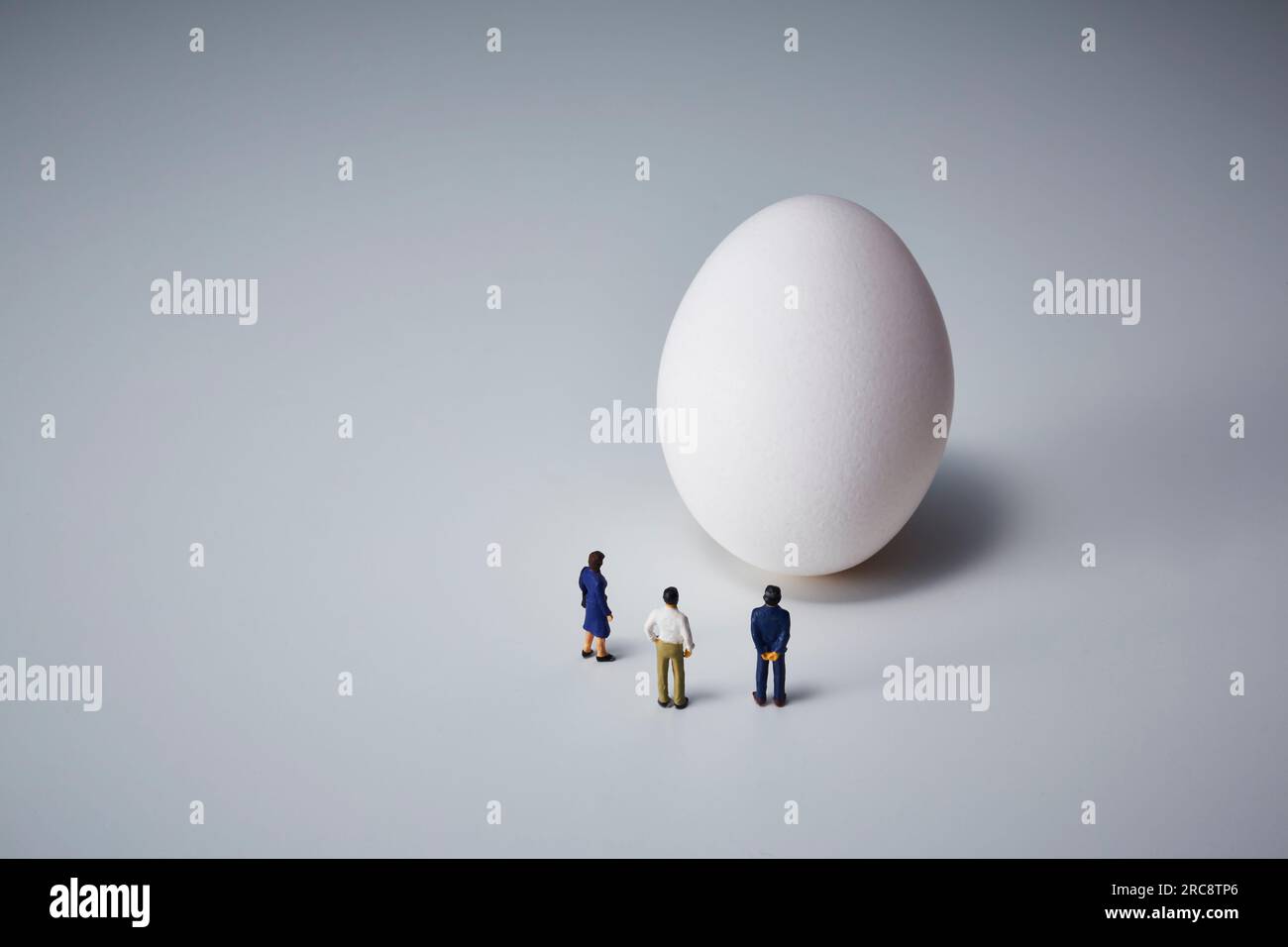 miniature people with white egg Stock Photo - Alamy