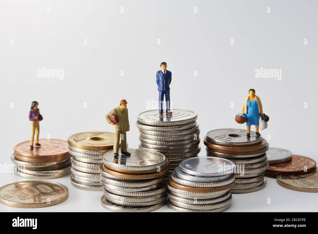 Miniature people standing on a stack of Japanese coins Stock Photo - Alamy