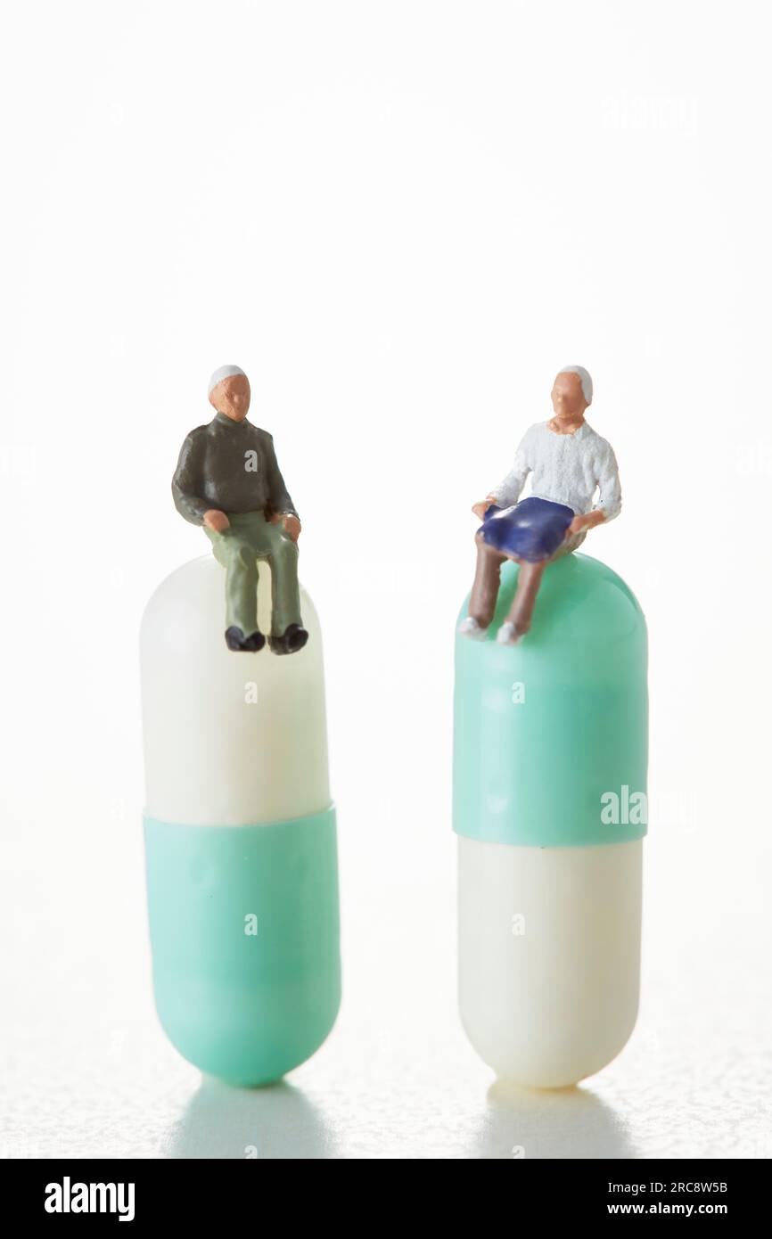 Miniature two old men sitting on capsule pills Stock Photo - Alamy
