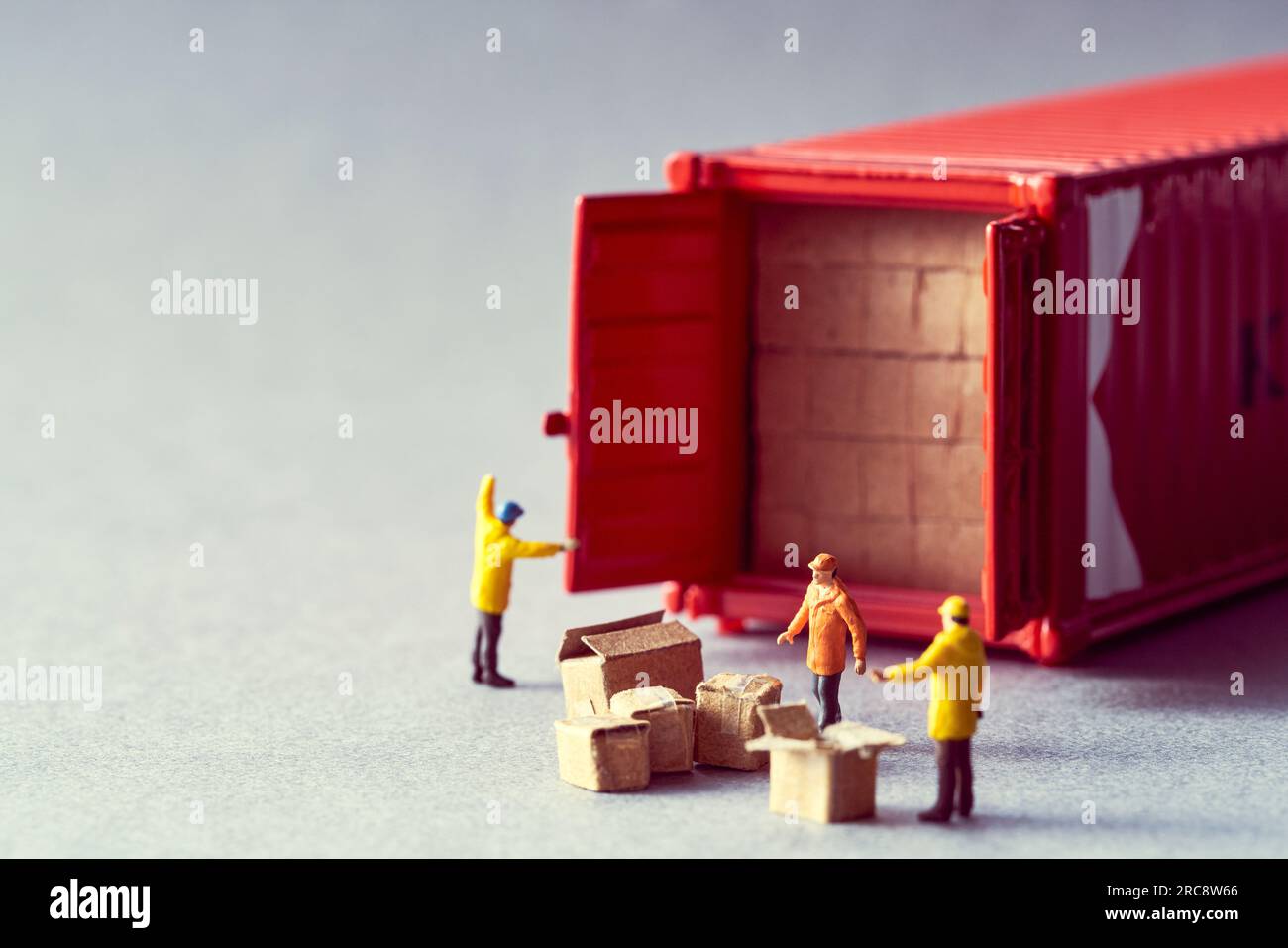 Dolls carrying cardboard boxes in miniature container Stock Photo - Alamy