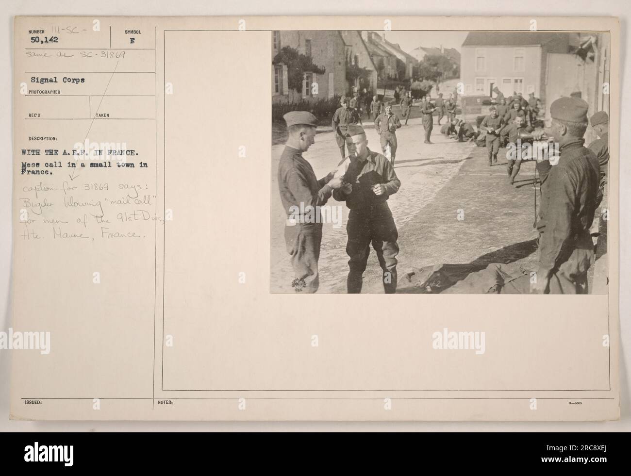 Soldiers gather for a mess call in a small town in France during World ...