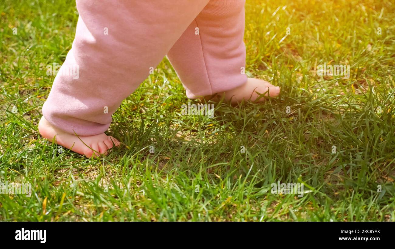 Toddler child makes confident steps on meadow green grass Stock Photo ...