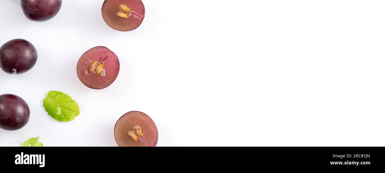 Delicious bunch of purple grapes fruit spilled over white table ...