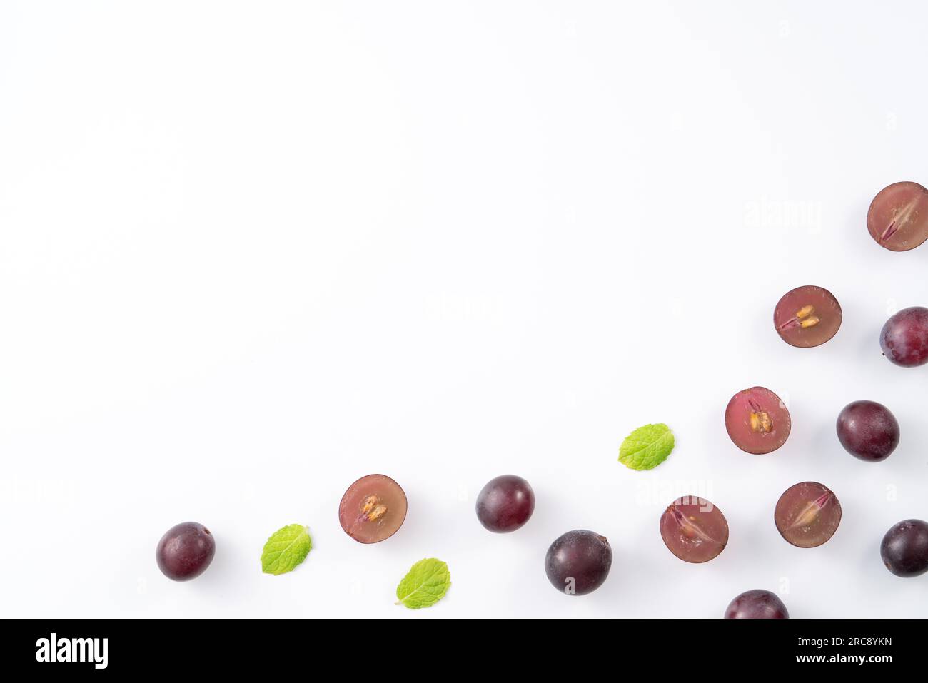 Delicious bunch of purple grapes fruit spilled over white table ...