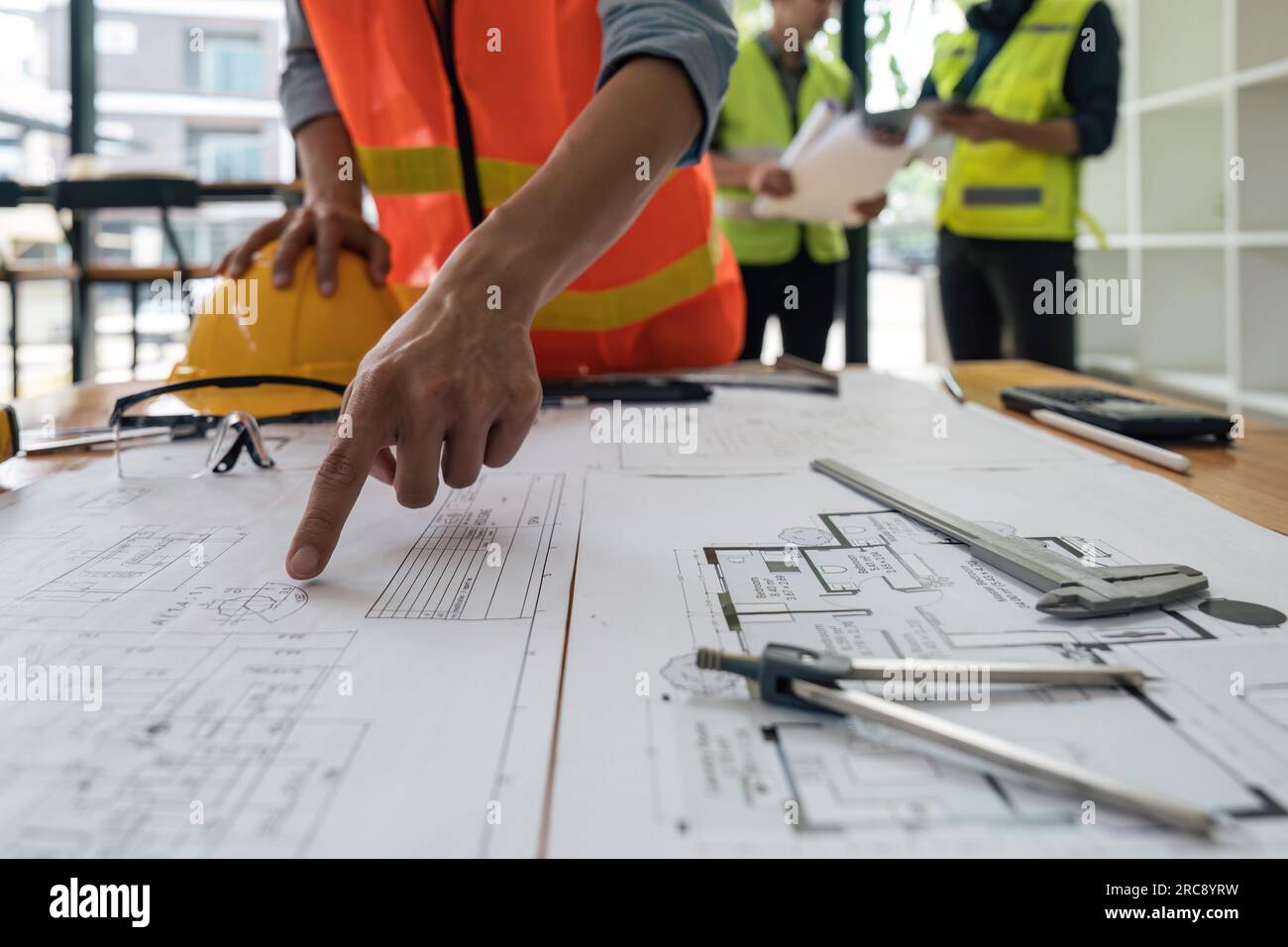 Engineers working on blueprints and construction plans. Building ...