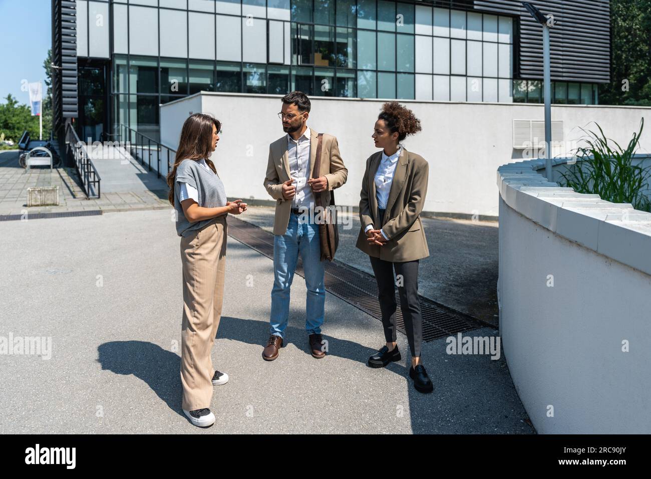 Group of business people walk outside in front of office buildings ...