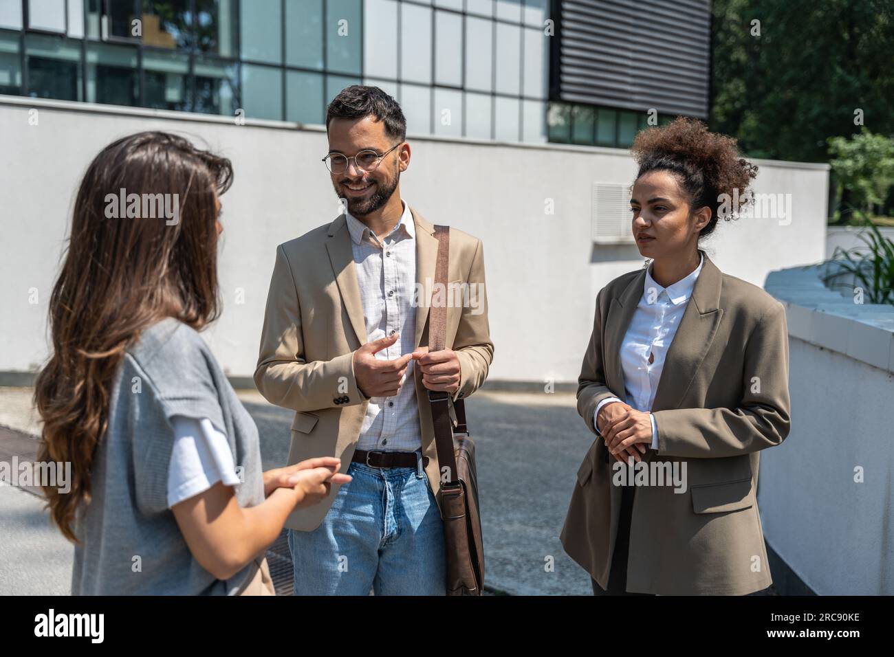 Group of business people walk outside in front of office buildings ...