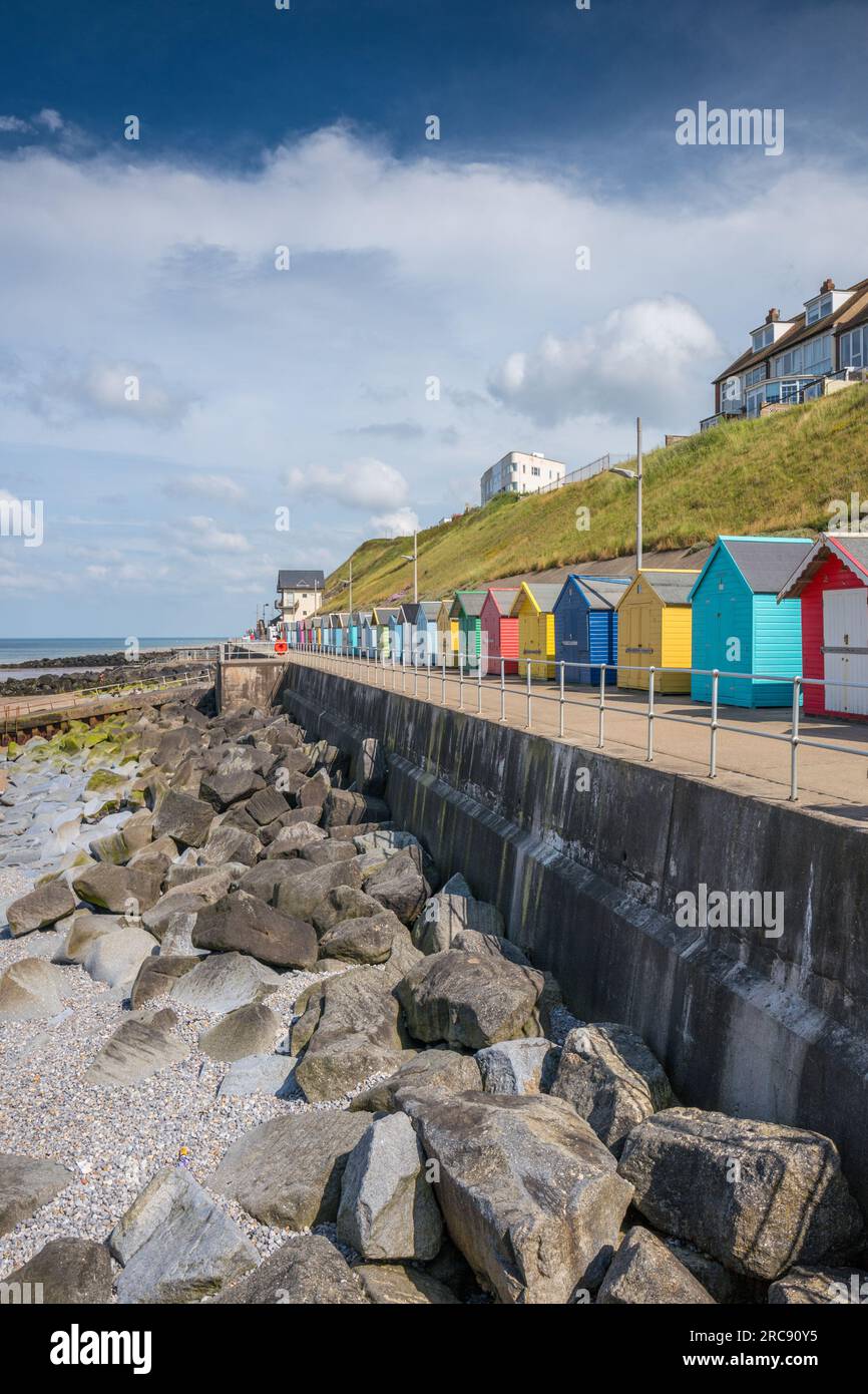 Colourful beach huts on top of the sea defences at the coastal town of ...