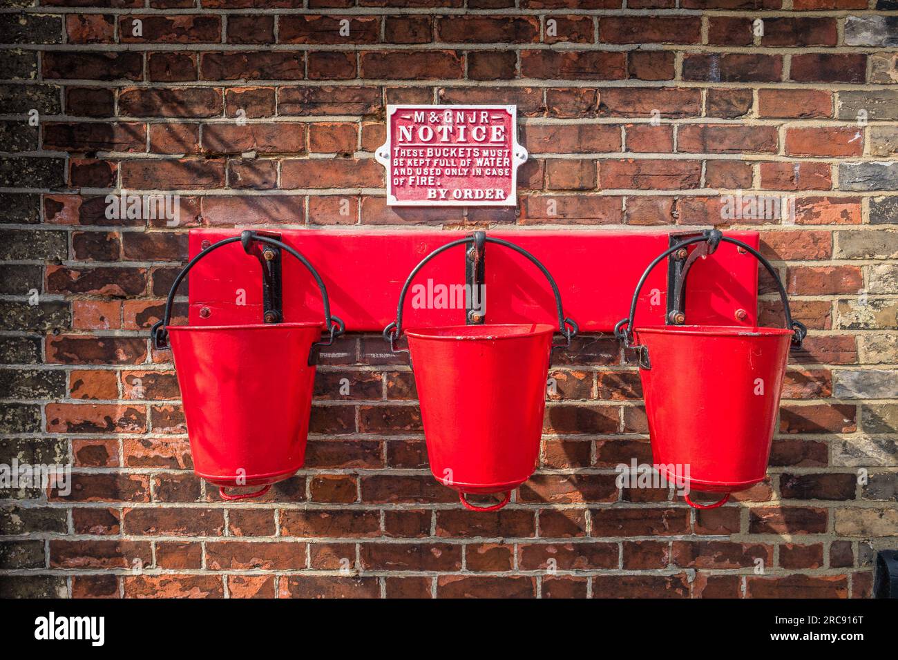 Three red fire bucket hanging on the wall at the preserved historic ...