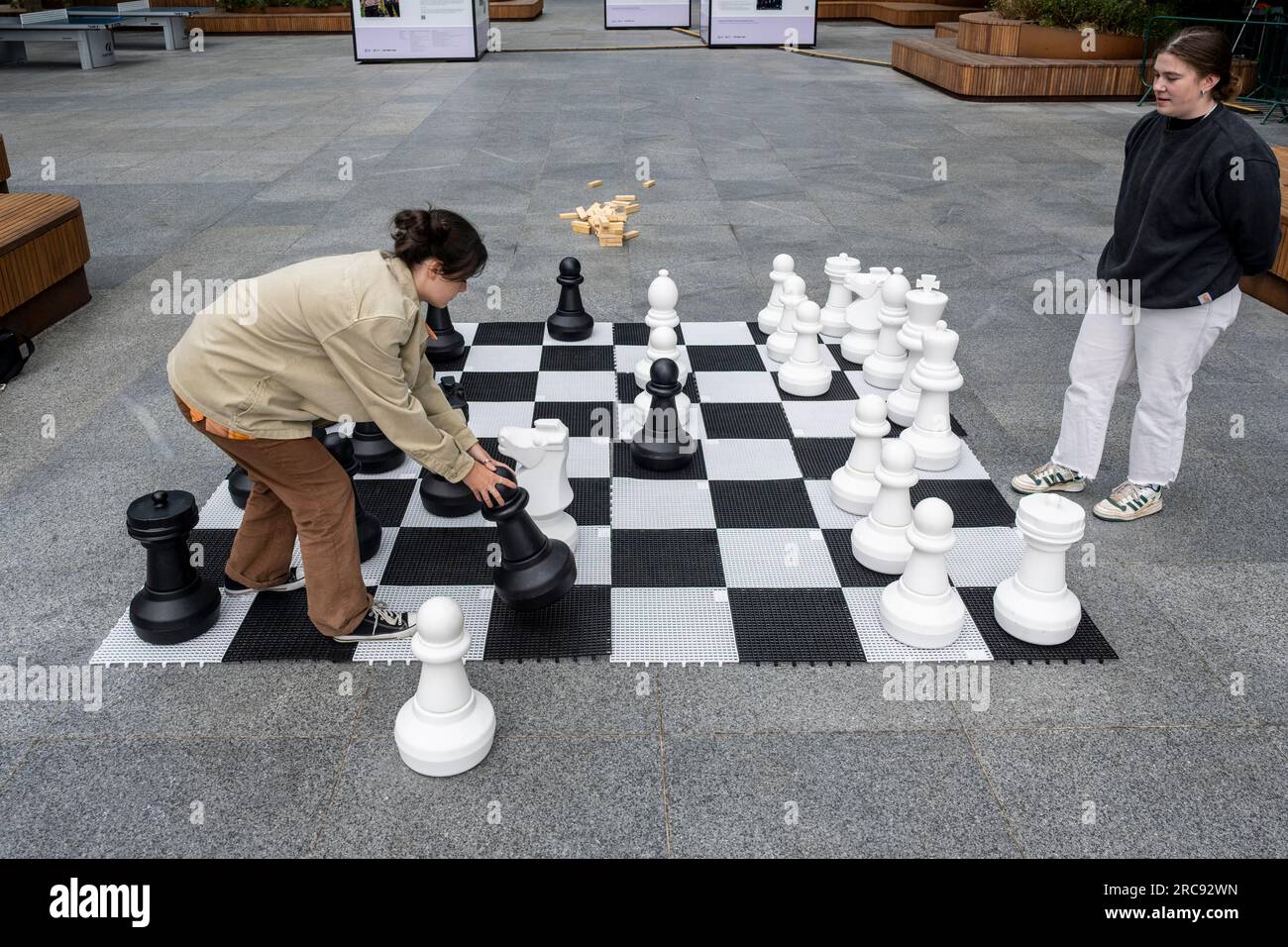 London, UK. 13 July 2023. Women playing giant outdoor chess in Euston ...