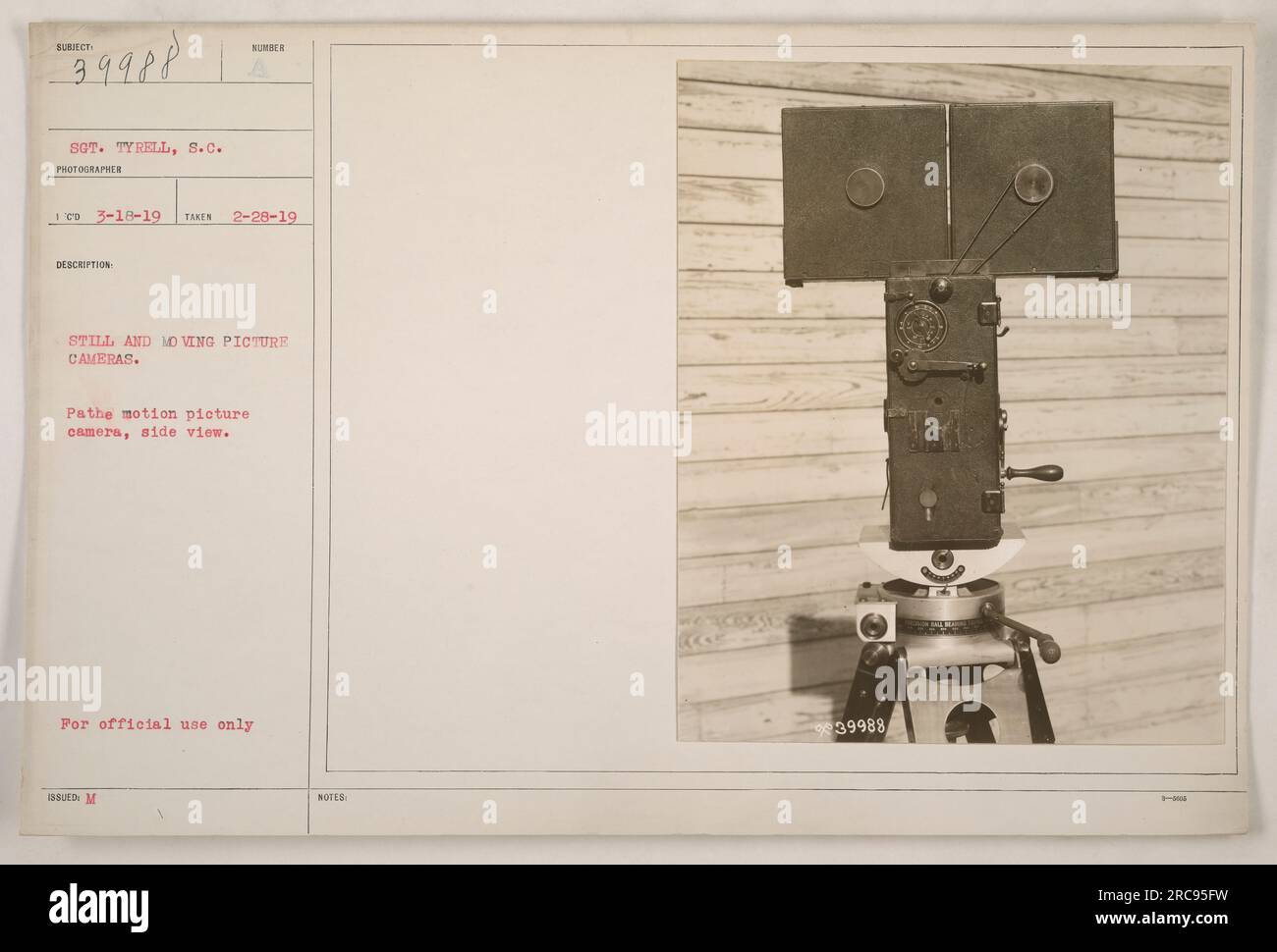A Pathe motion picture camera is photographed in a side view. The image ...