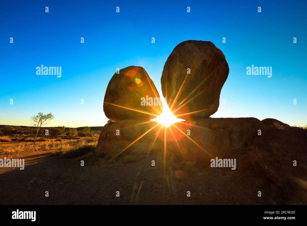 Sunbeams at dawn behind iconic Devils Marbles: Eggs of mythical Rainbow ...