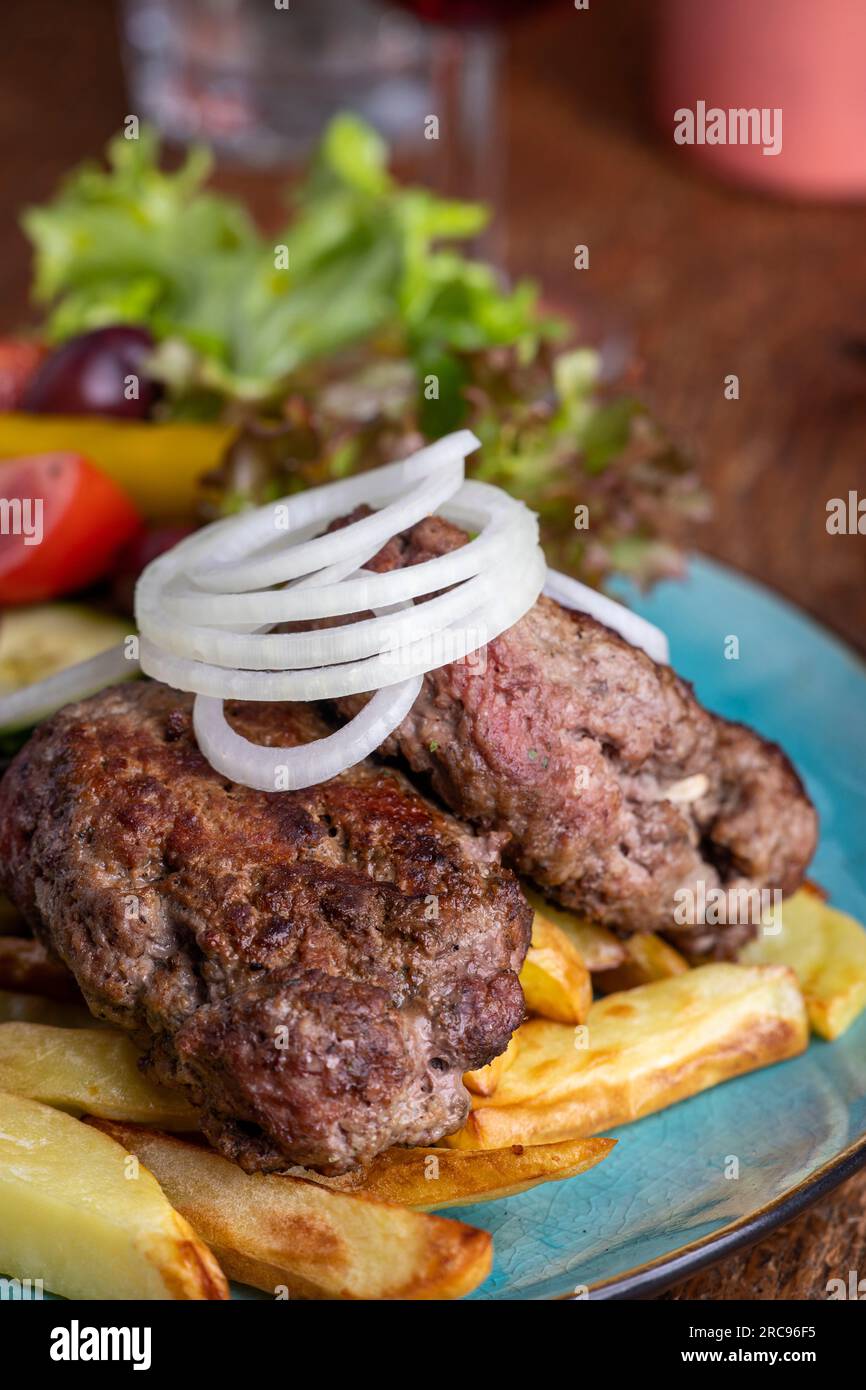 greek bifteki with salad and fries Stock Photo - Alamy