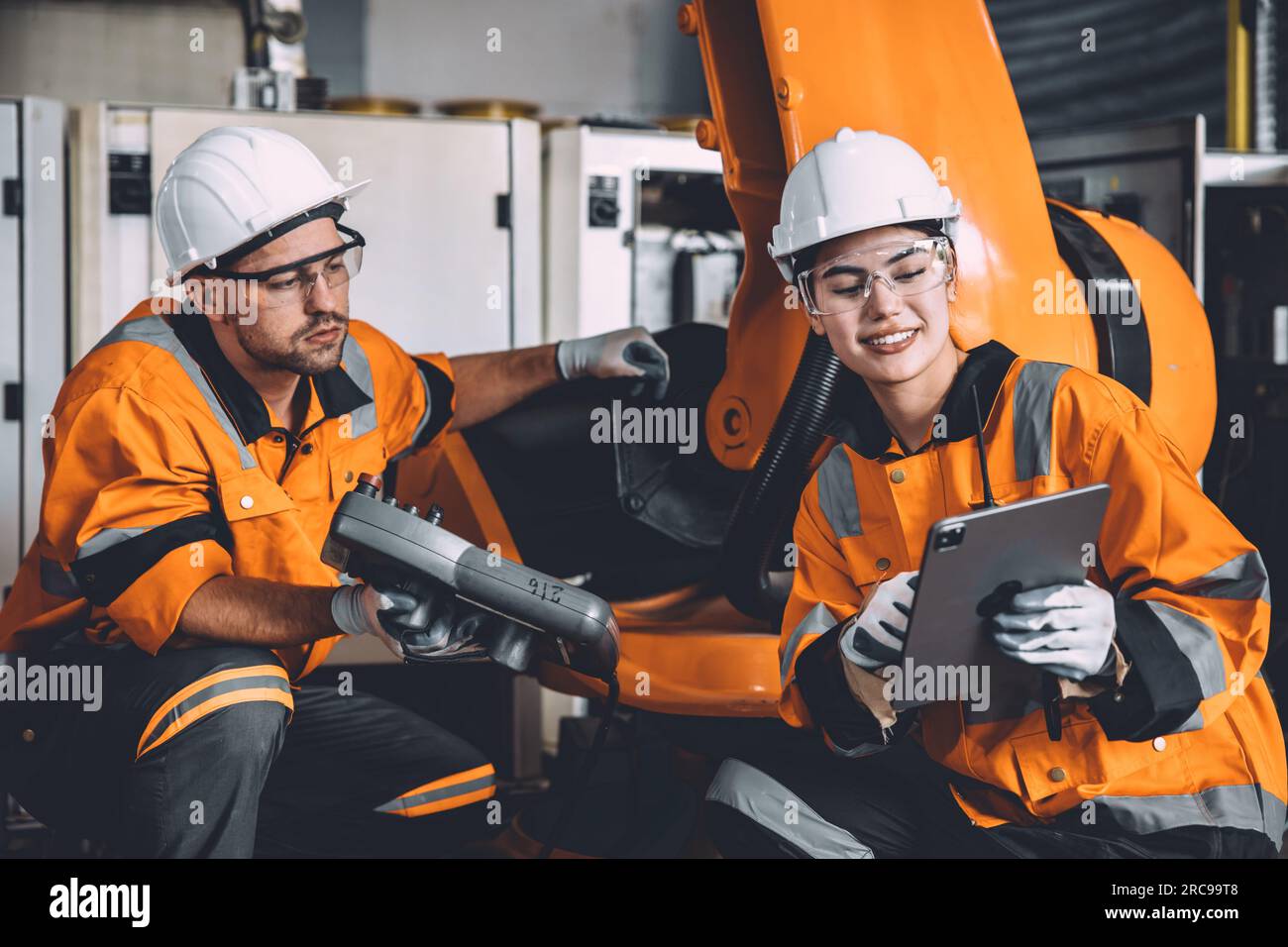 Happy Engineer Team Working In Modern Automation Factory With Welding Robot Arm Control Training