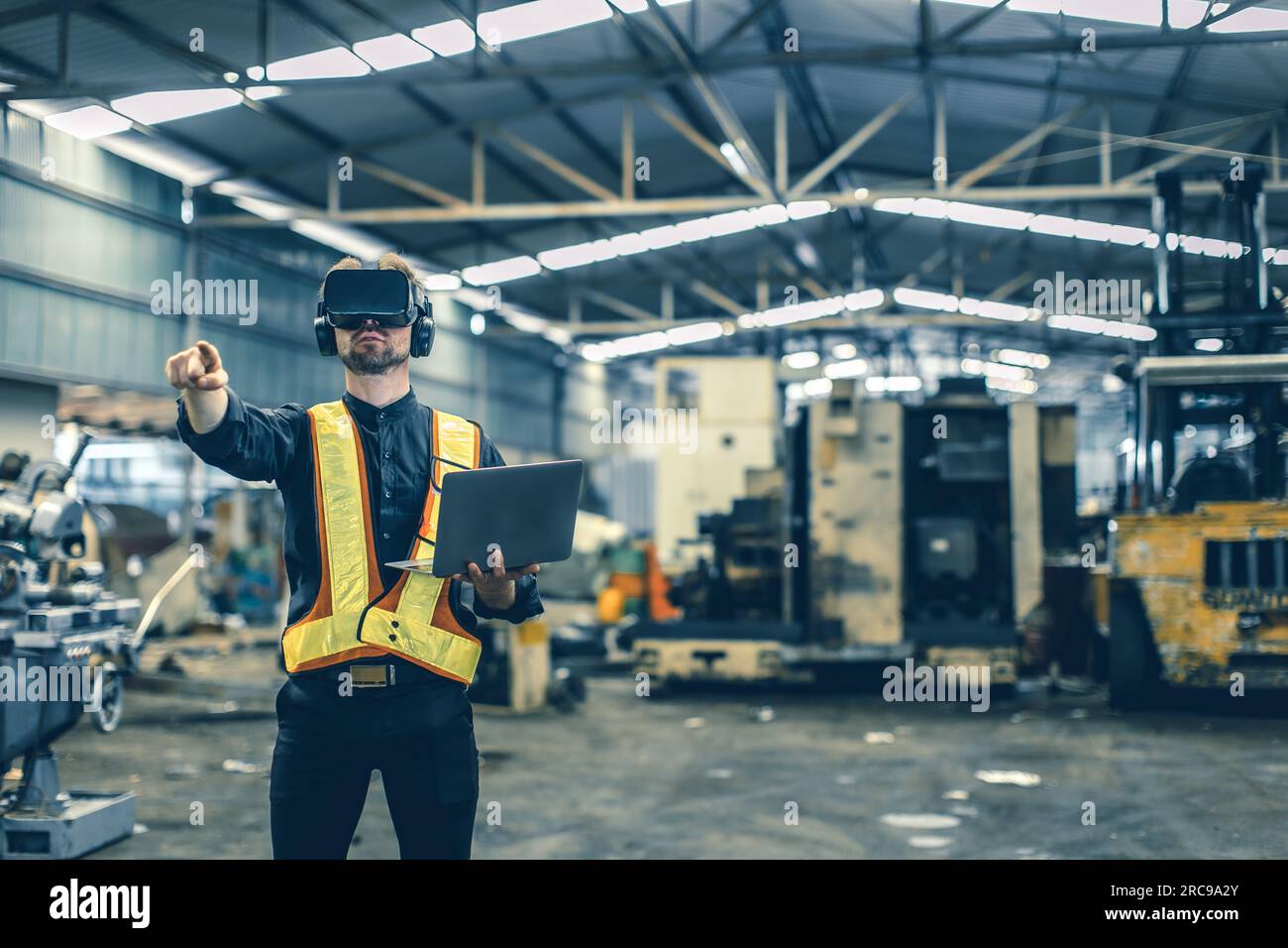 Engineer male using VR virtual reality technology in modern warehouse ...