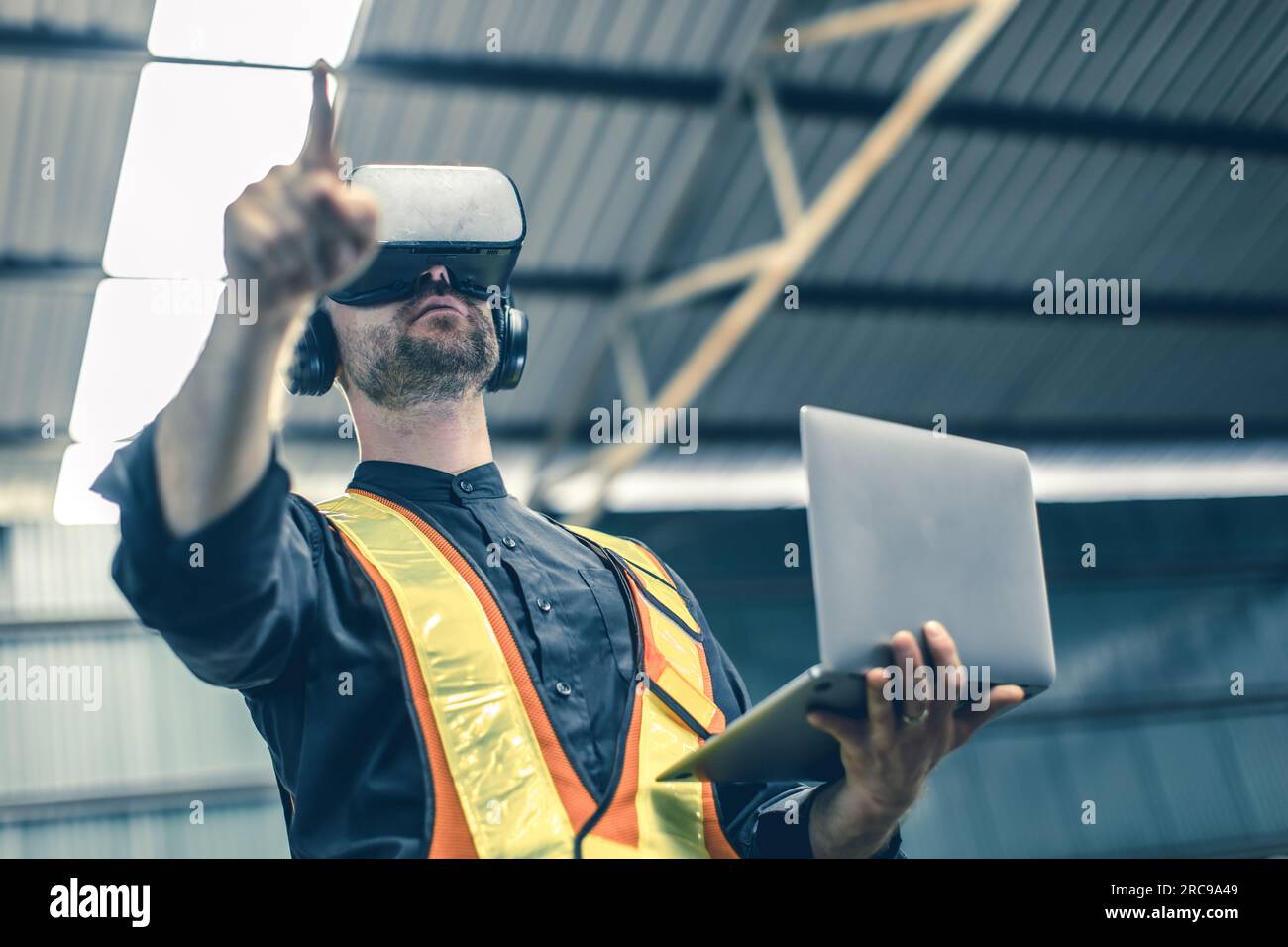 Engineer male using VR virtual reality technology in modern warehouse ...