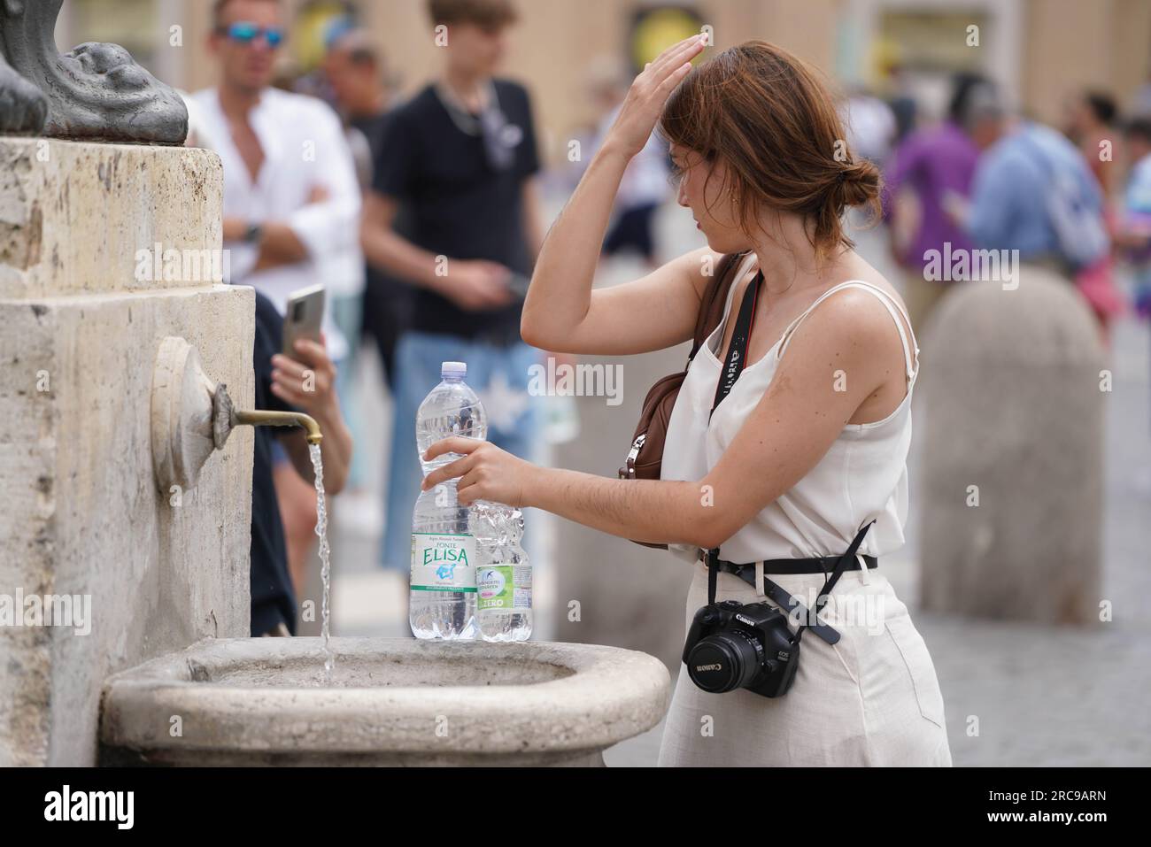 Rome, Italy. 13 July 2023 People take refreshments from a fountain, as ...