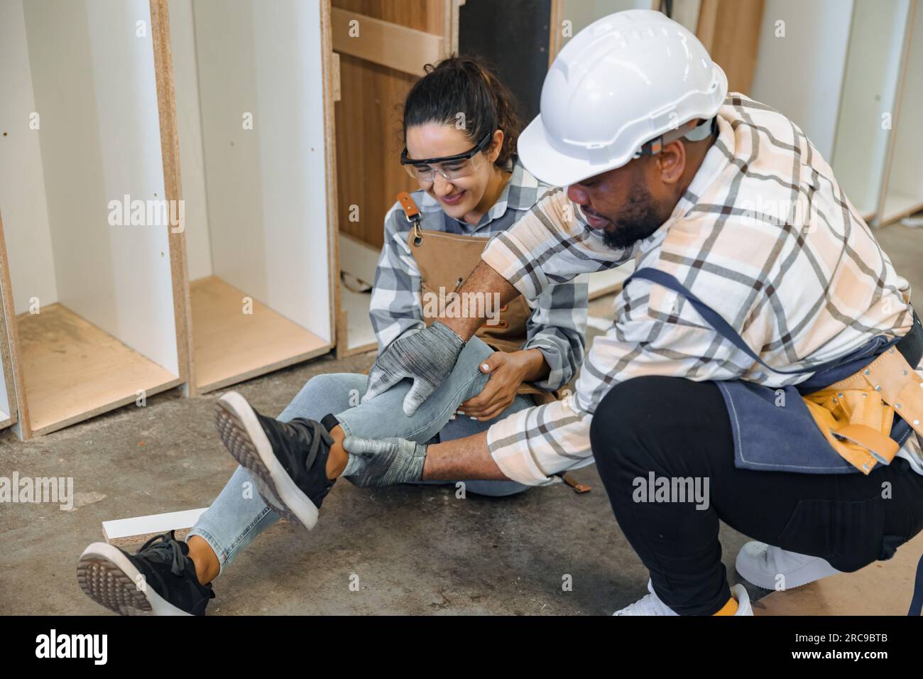 women worker fall accident in workshop. factory staff employee suffers leg injury at work team ...