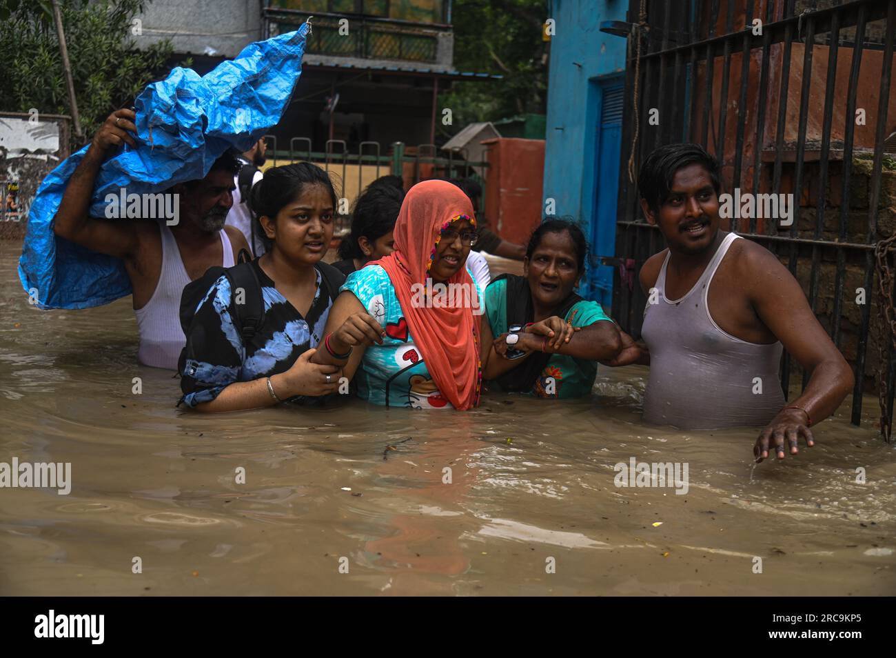 New Delhi, Delhi, India. 13th July, 2023. People wade through a flooded ...