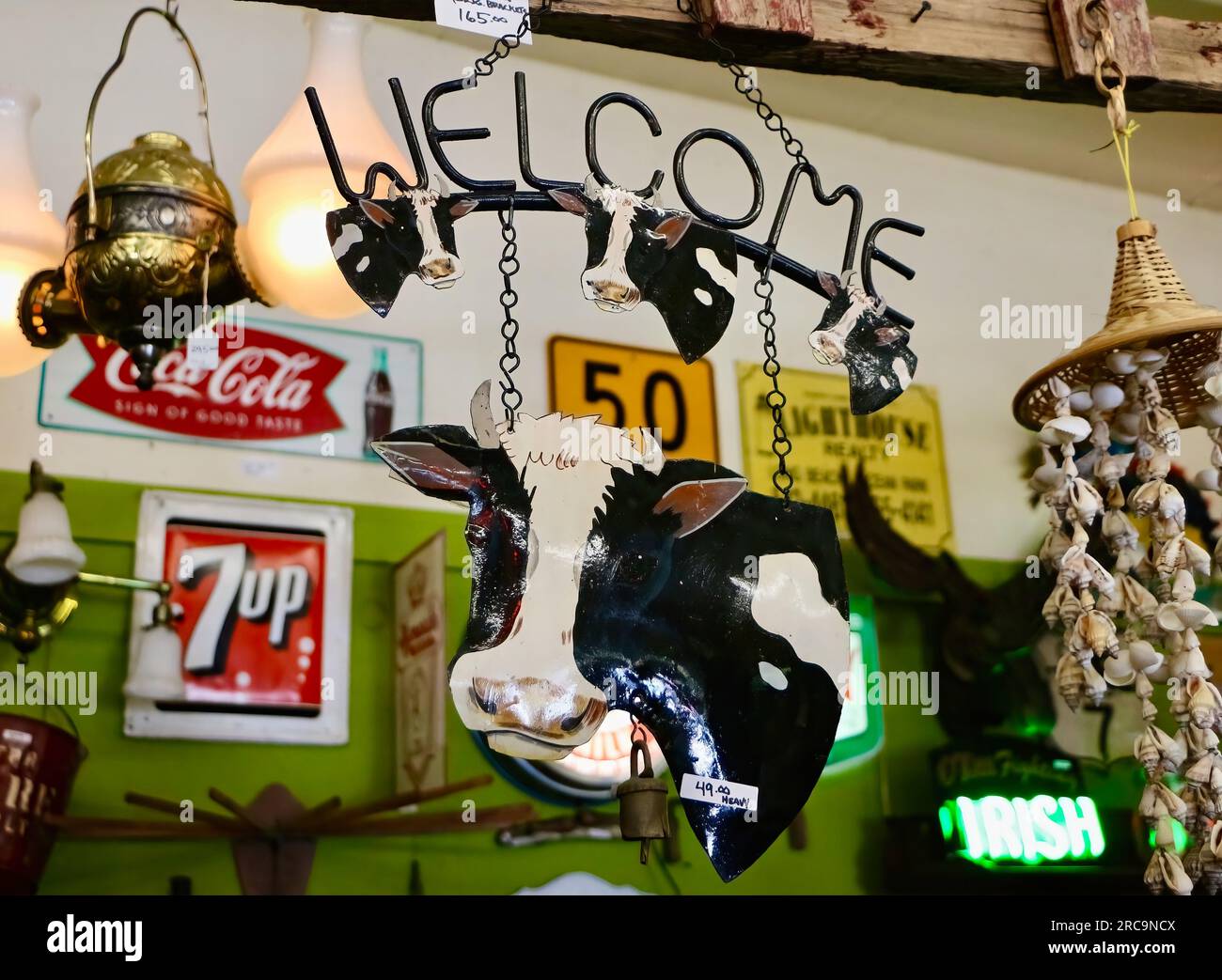 Photo of a hanging metal welcome sign with black and white cows faces ...
