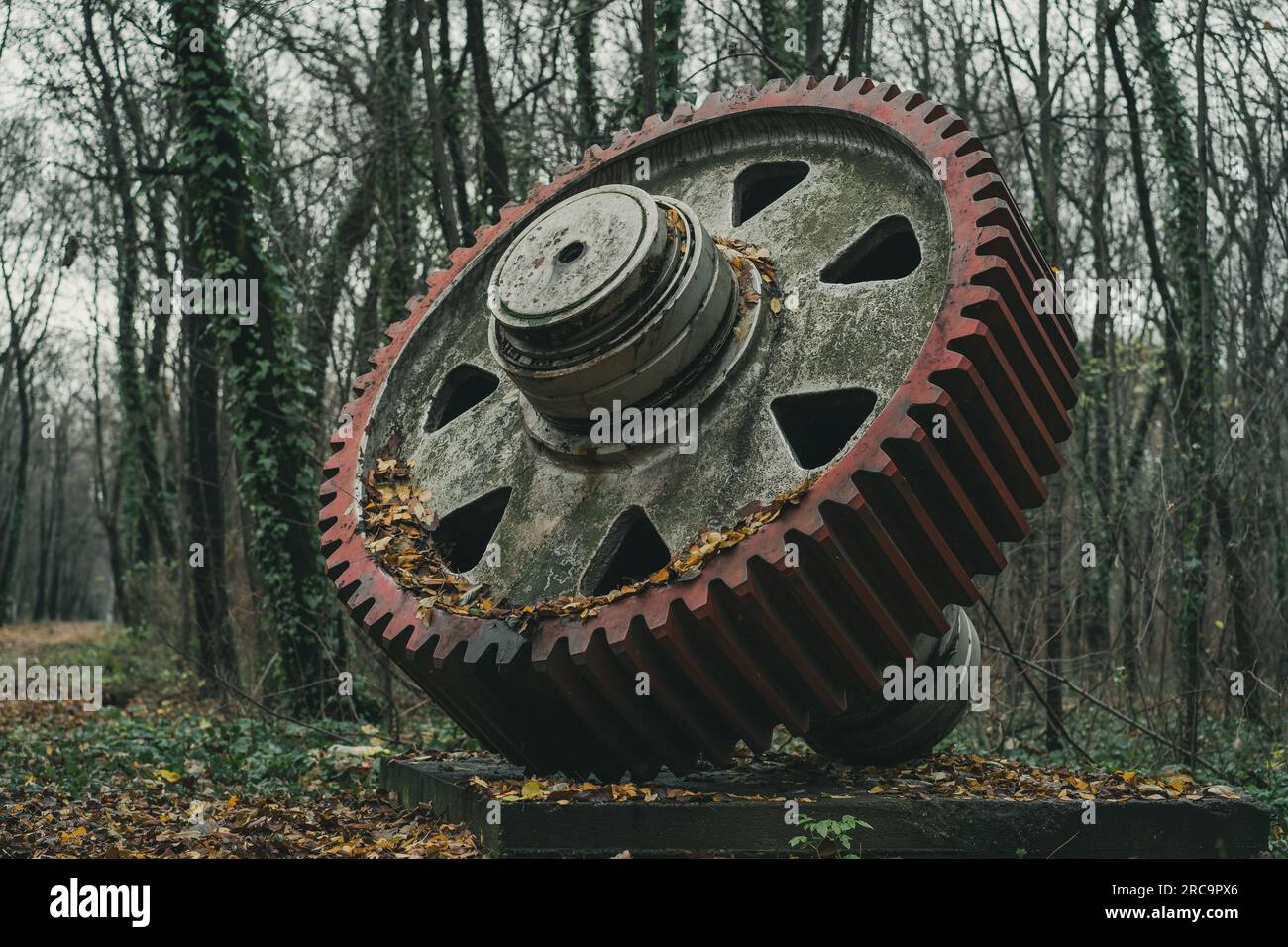 An old unused gigantic gear in the forest. Industrial history machine ...